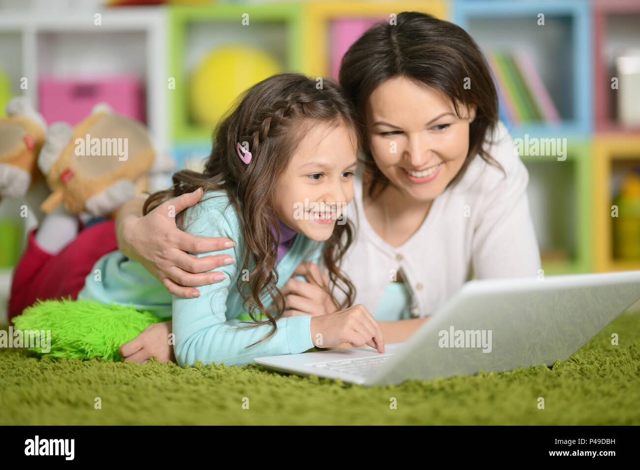 Mother and daughter using laptop together Stock Photo - Alamy