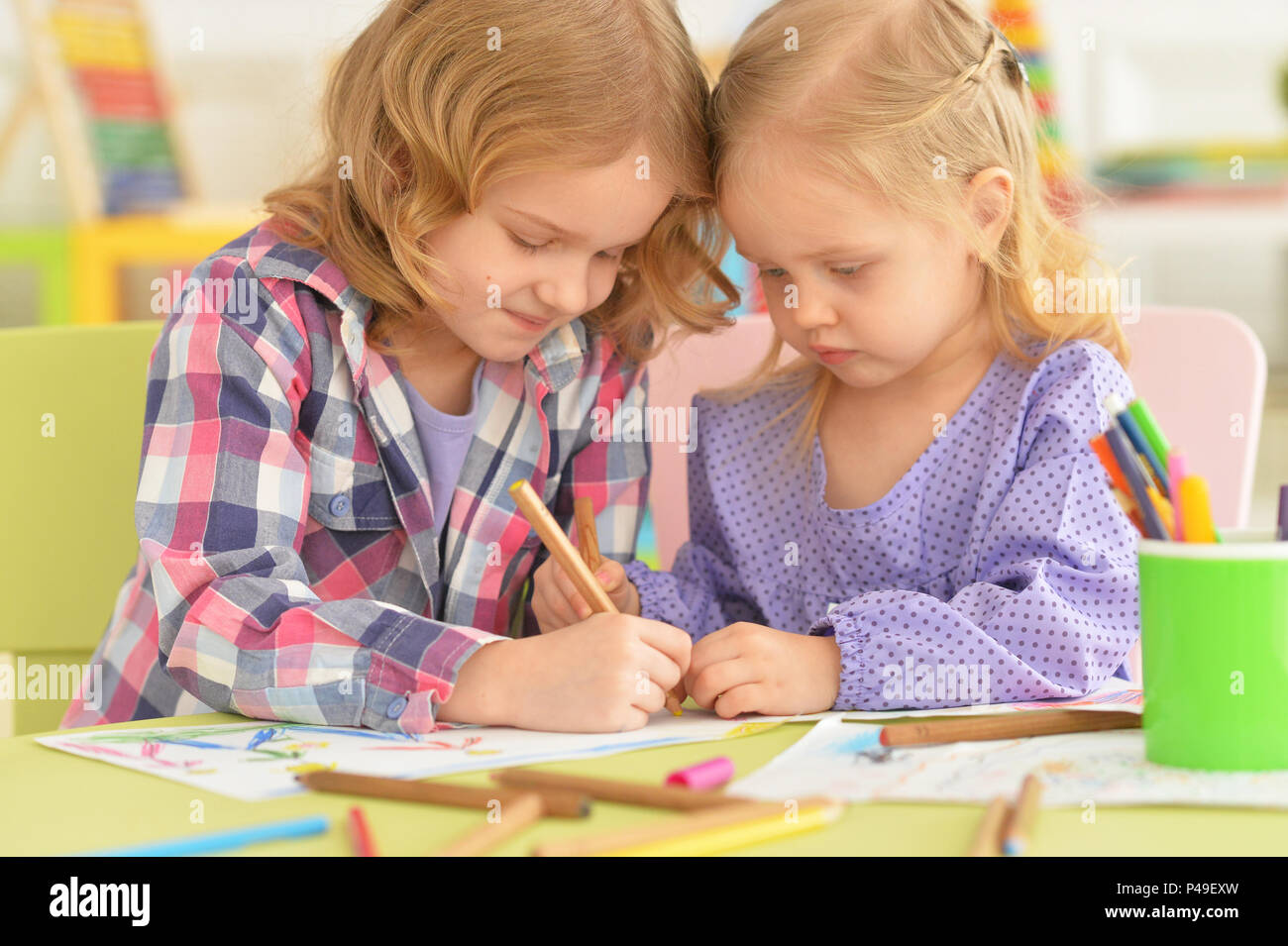 Cute little girls drawing with pencils Stock Photo - Alamy