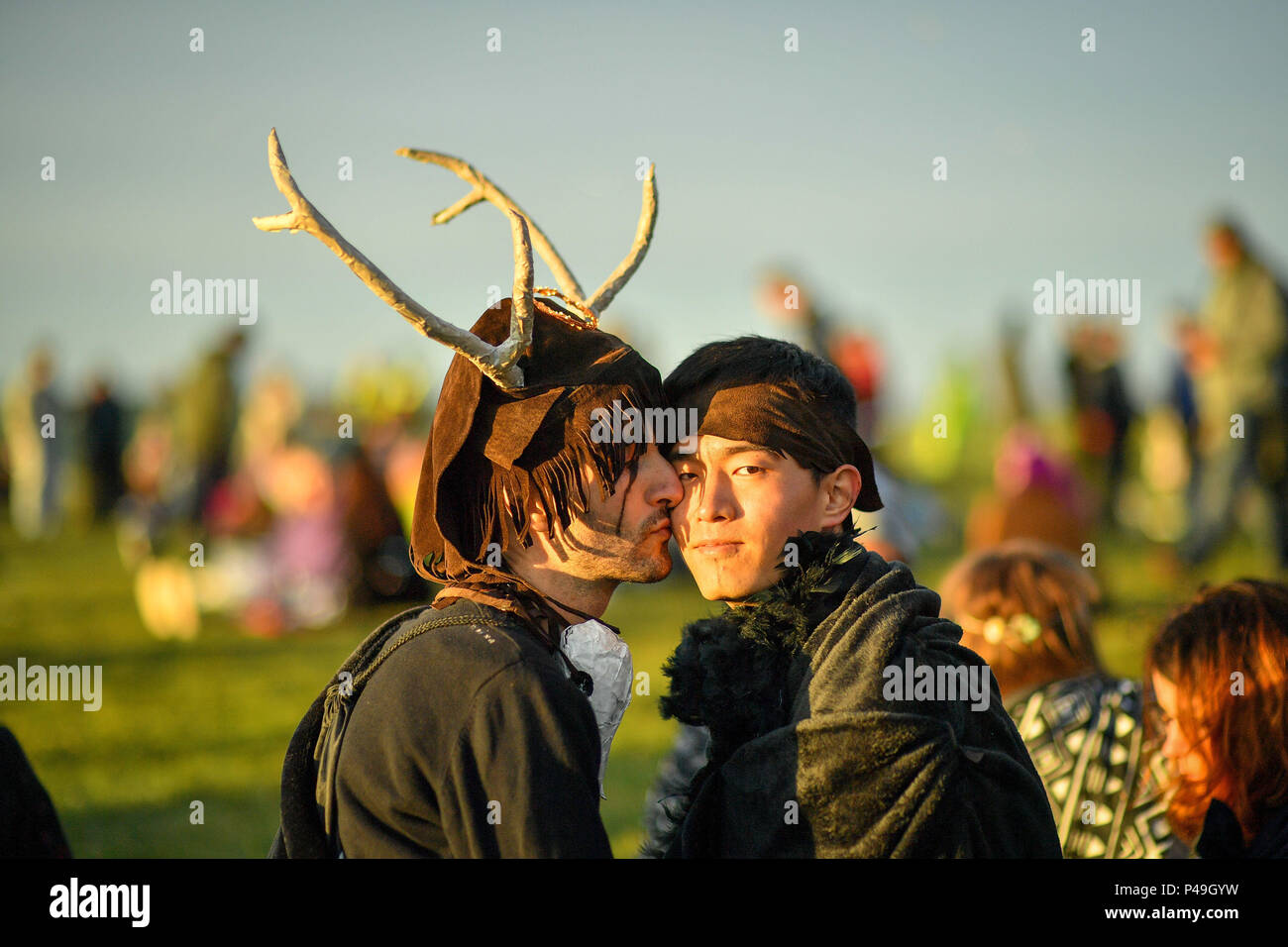 A man wears a hat with antlers as the sun rises at Stonehenge onto ...