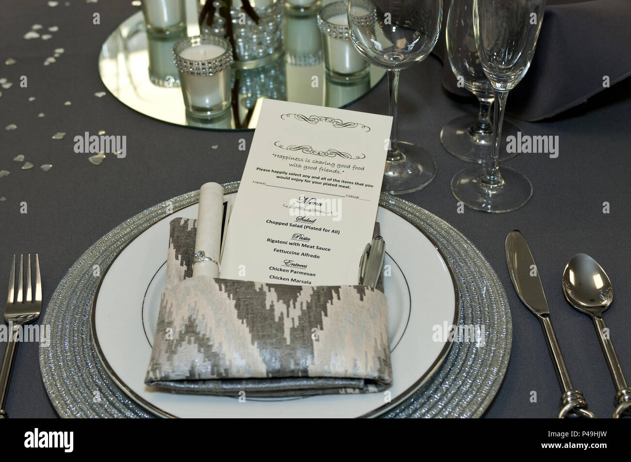 Beautiful and stylish wedding table set up with white and silver plates ...