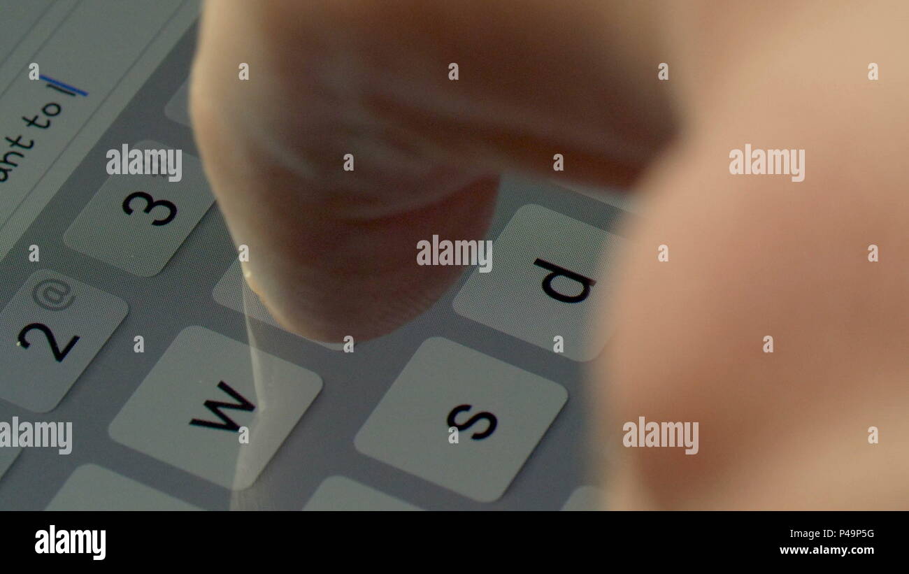 Close-up view fingers tapping keypad of tablet and writing message on ...