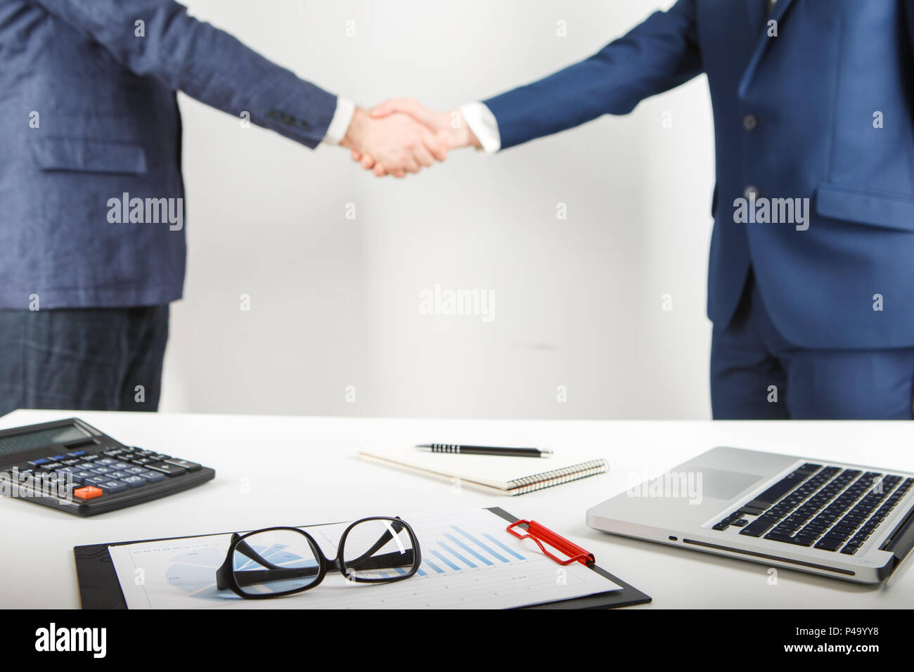 Business handshake. Business people discussing the charts and graphs ...