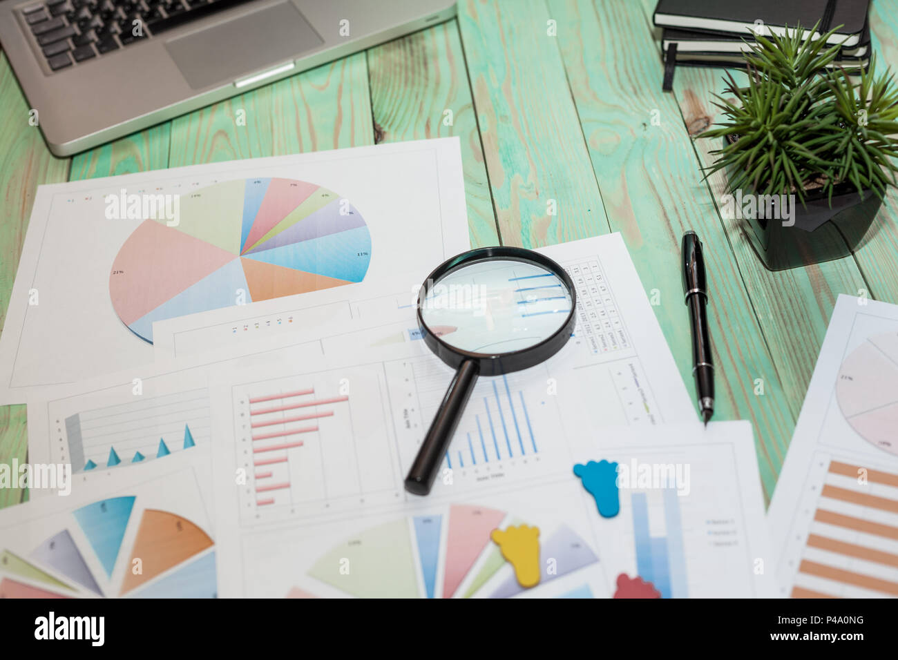 Business Desktop. Looking at growth chart with magnifying glass. Graphs ...