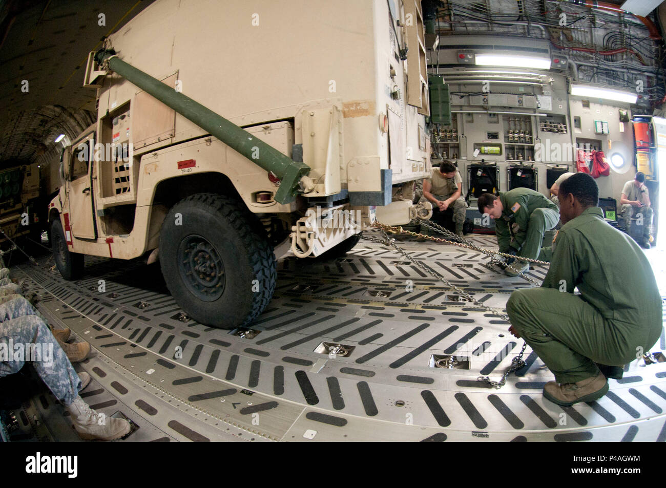 C-17 loadmasters with the 62nd Airlift Wing tie down a vehicle before ...