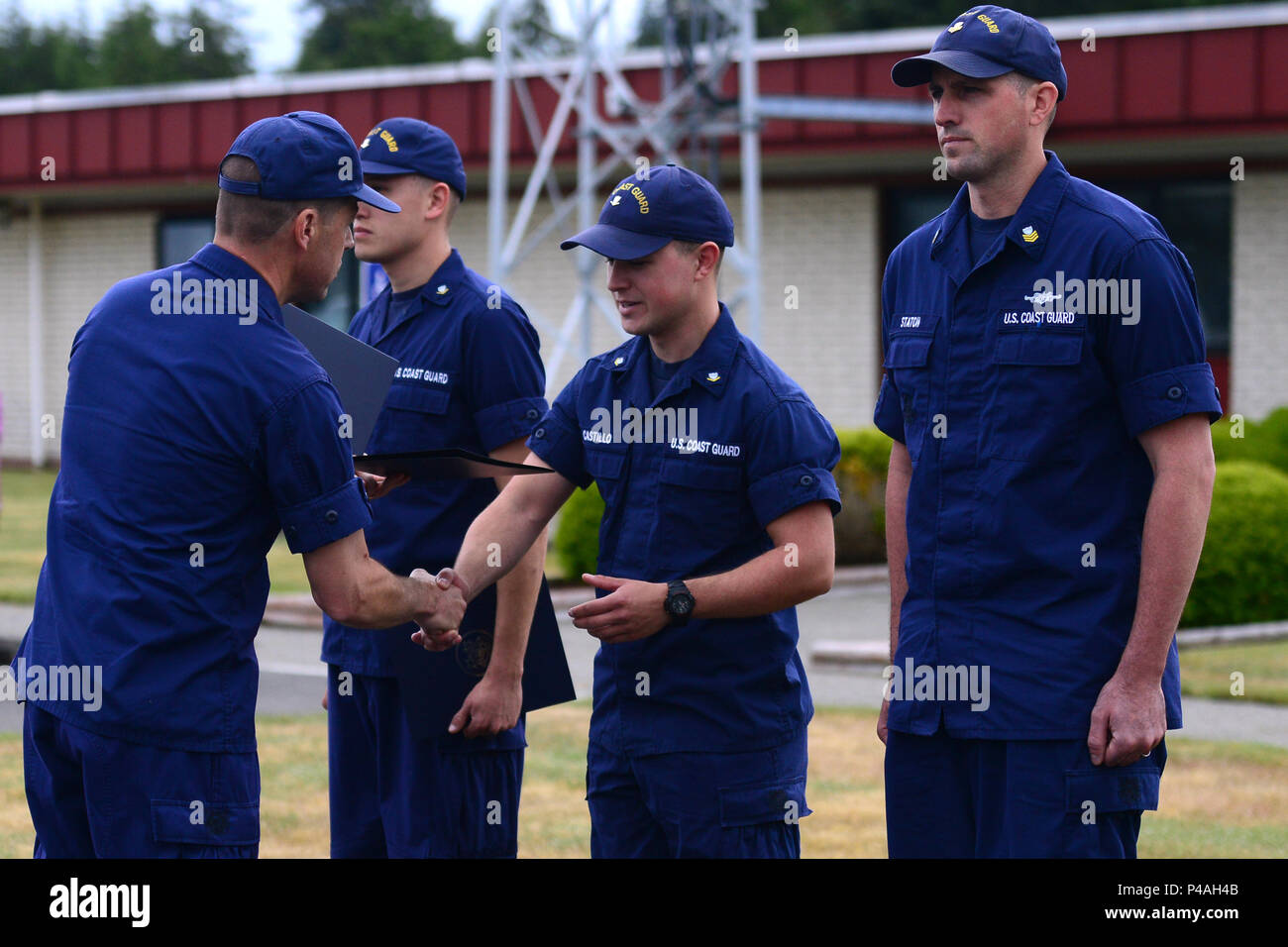 Capt. Joe Raymond, commander, Coast Guard Sector Puget Sound, hands a ...