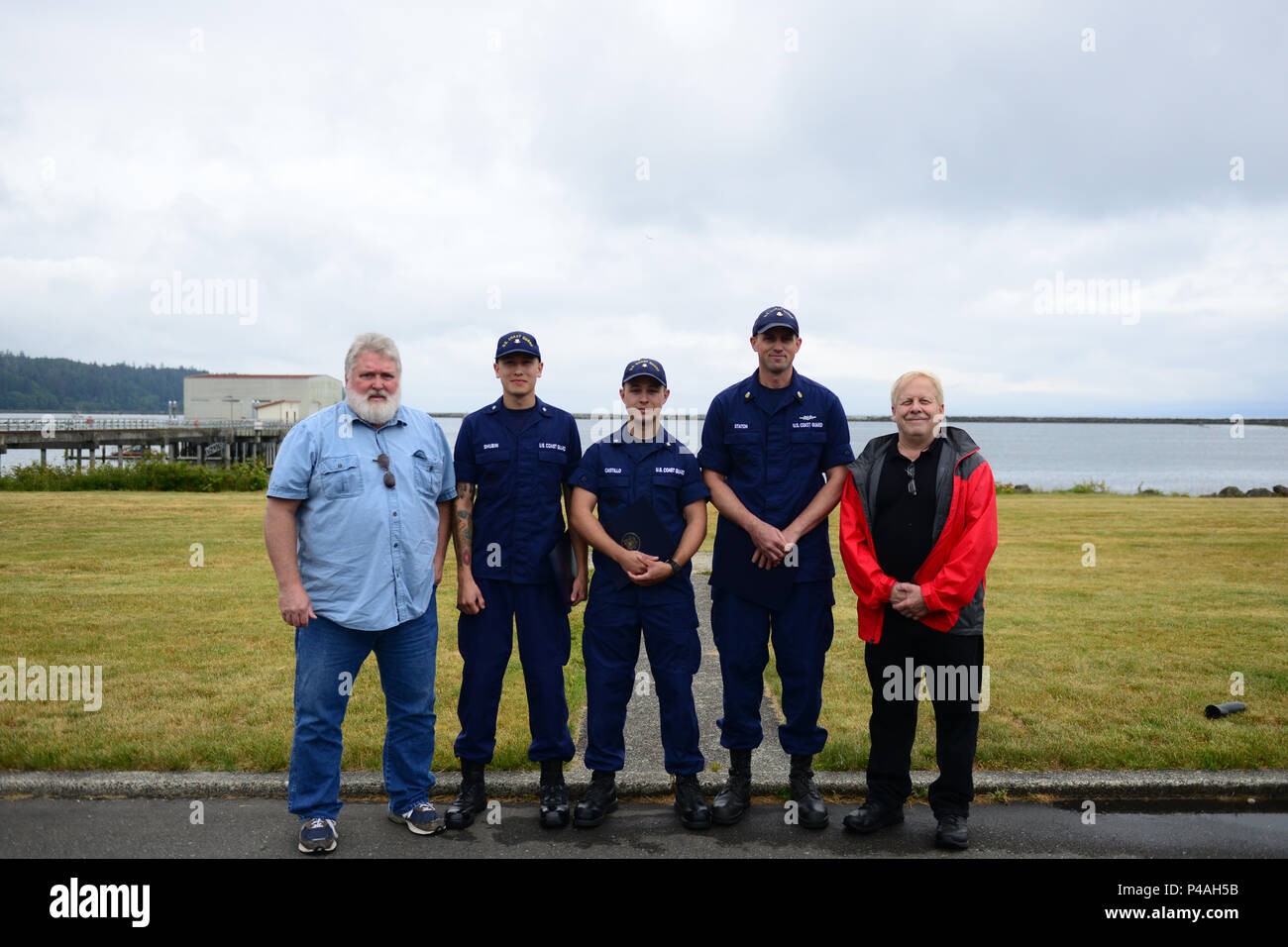 A Coast Guard 47-foot Motor Life Boat crew poses for a photo with two ...