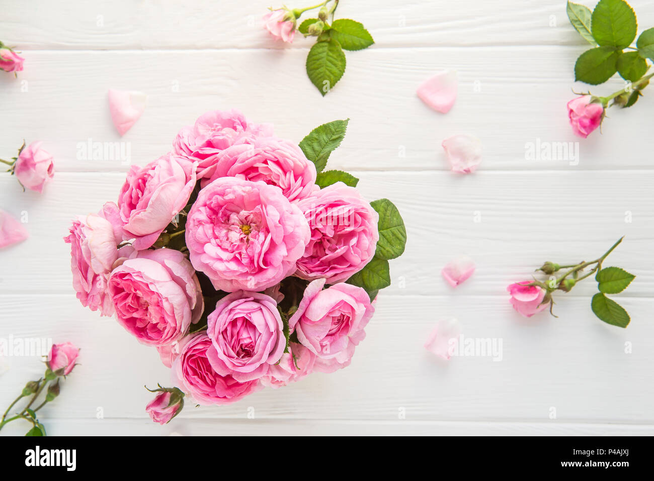 Top view tender pink tea roses bouquet on the rustic white wooden table ...