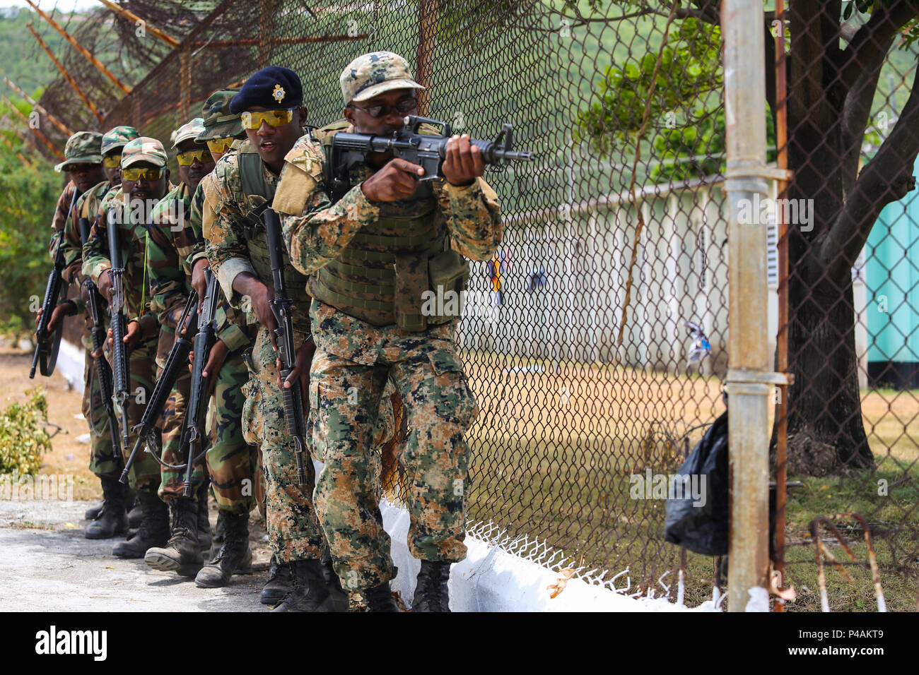 Multinational service members prepare to maneuver around a corner while ...