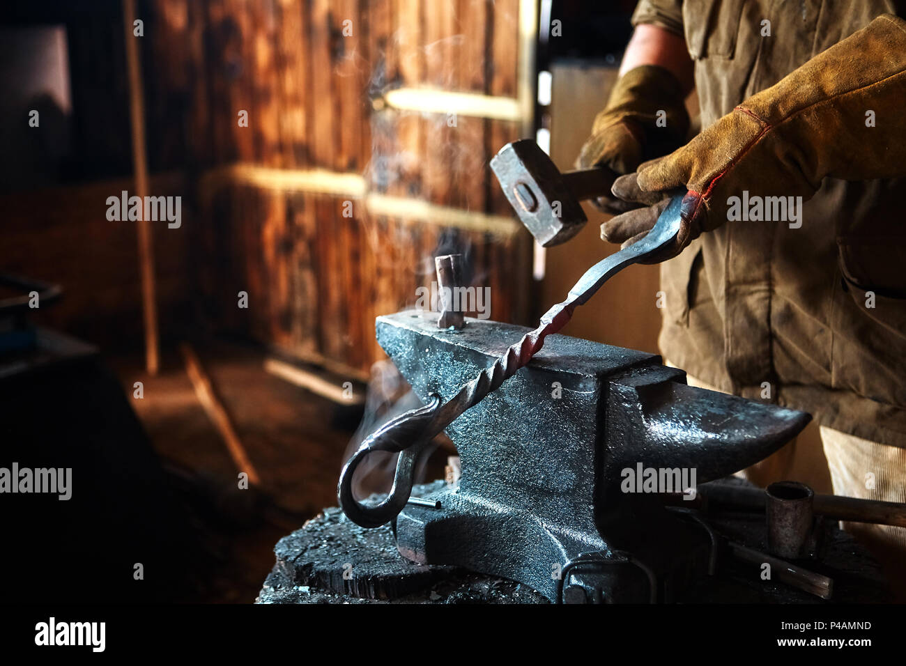 The hands of a blacksmith at work in the smithy Stock Photo - Alamy