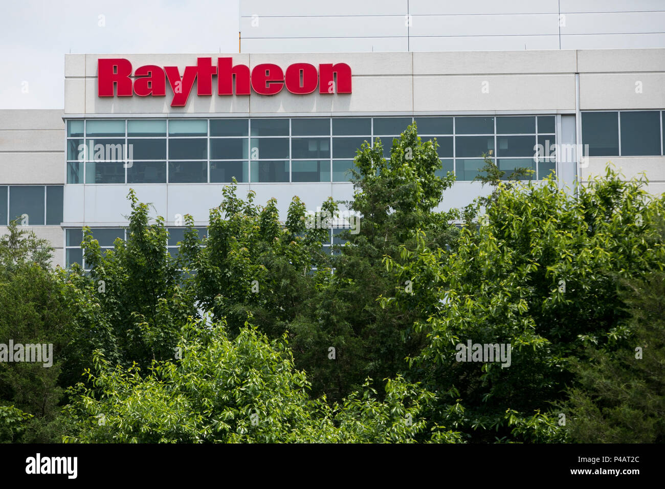 A logo sign outside of a facility occupied by The Raytheon Company in ...