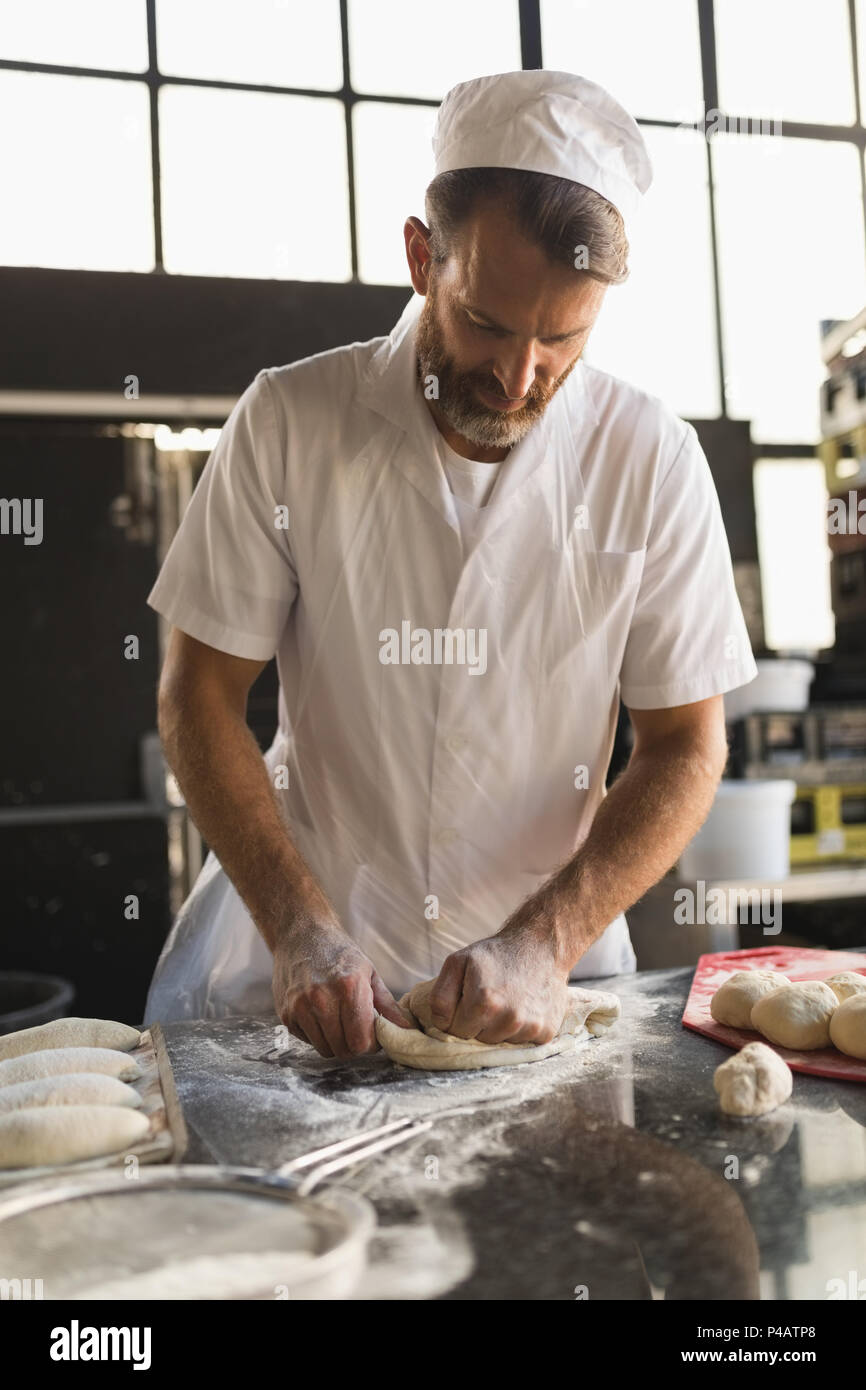 Male baker preparing dough in bakery shop Stock Photo - Alamy