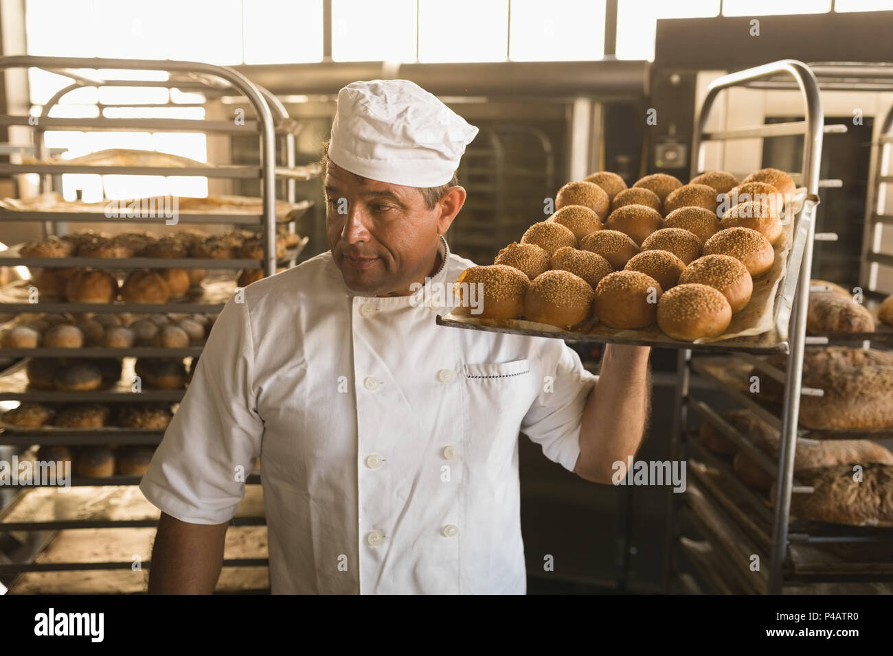 Male baker holding a tray of baked sweet foods Stock Photo - Alamy