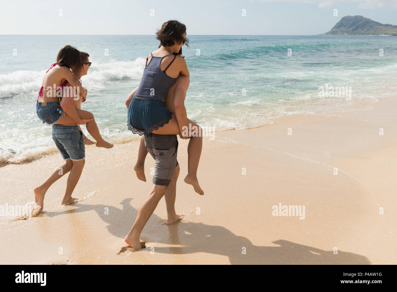 Two couples having fun in the beach Stock Photo - Alamy
