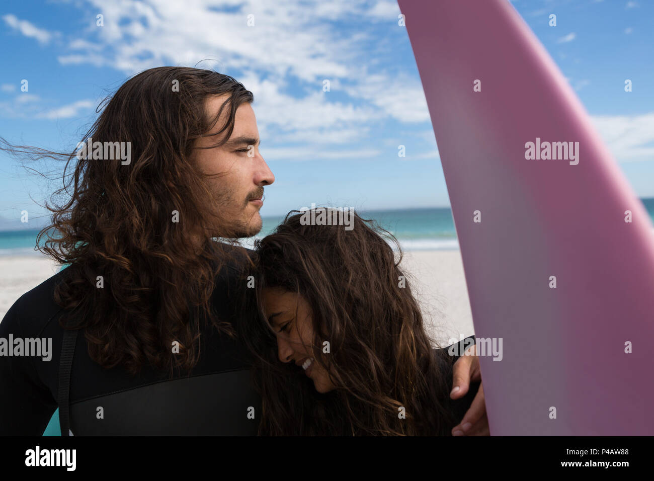 Surfer couple standing with surfboard in the beach Stock Photo - Alamy