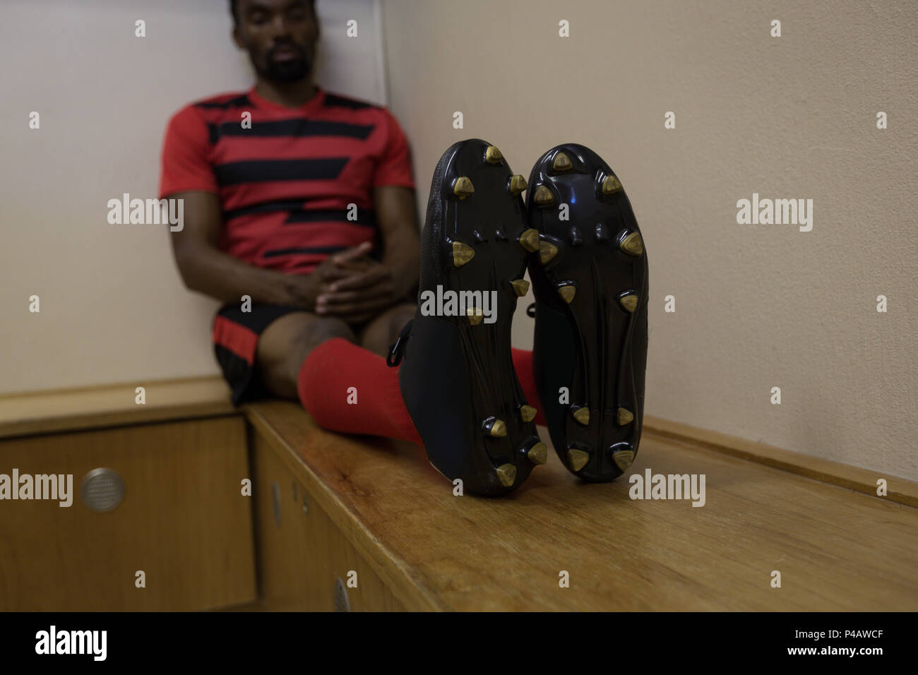 Football player relaxing on bench Stock Photo - Alamy
