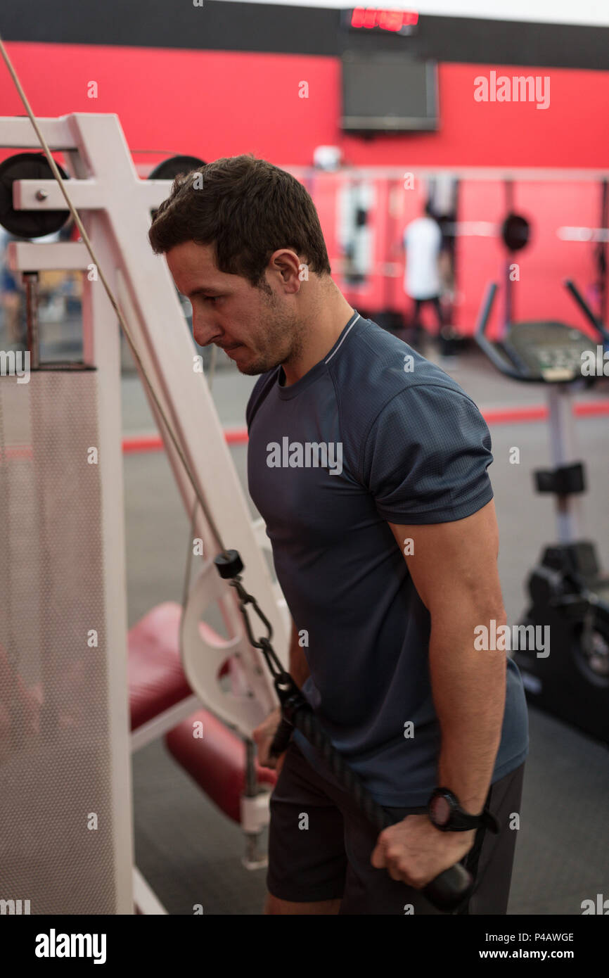 Man exercising with exercising equipment in gym Stock Photo - Alamy