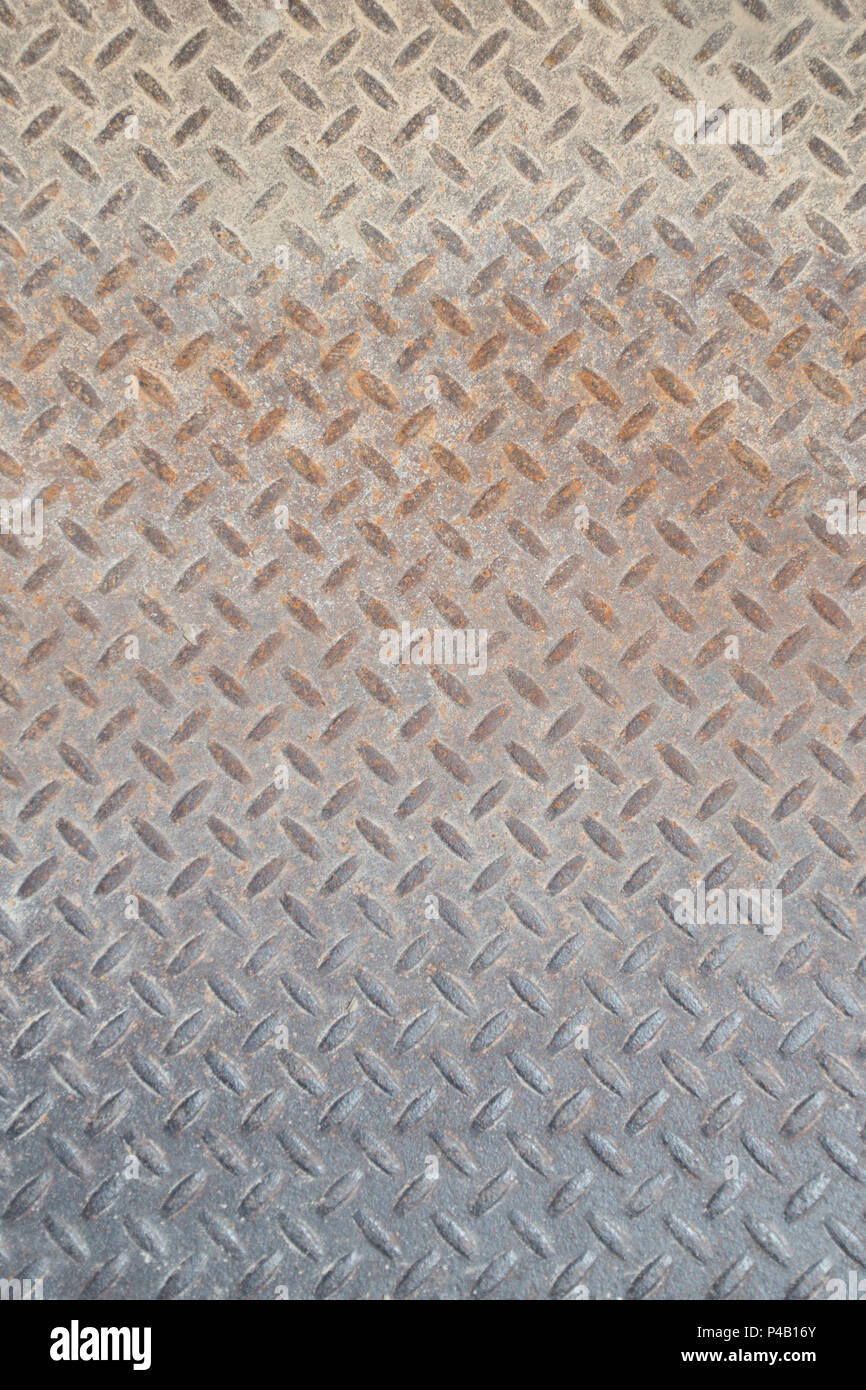 Closeup of a distressed, mottled, gungy industrial diamondplate ...