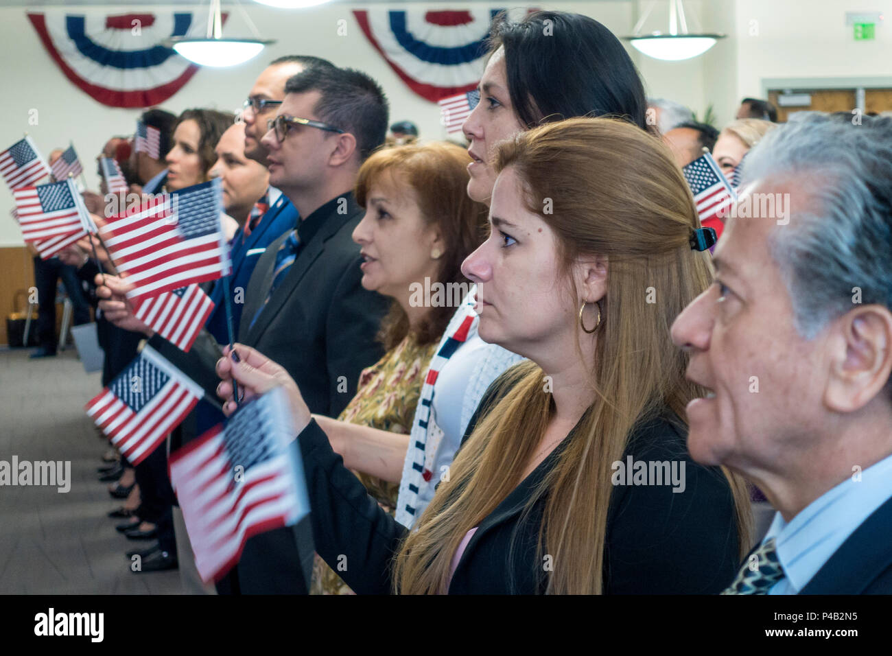Just sworn in as American Citizens, immigrants wave flags and hold ...