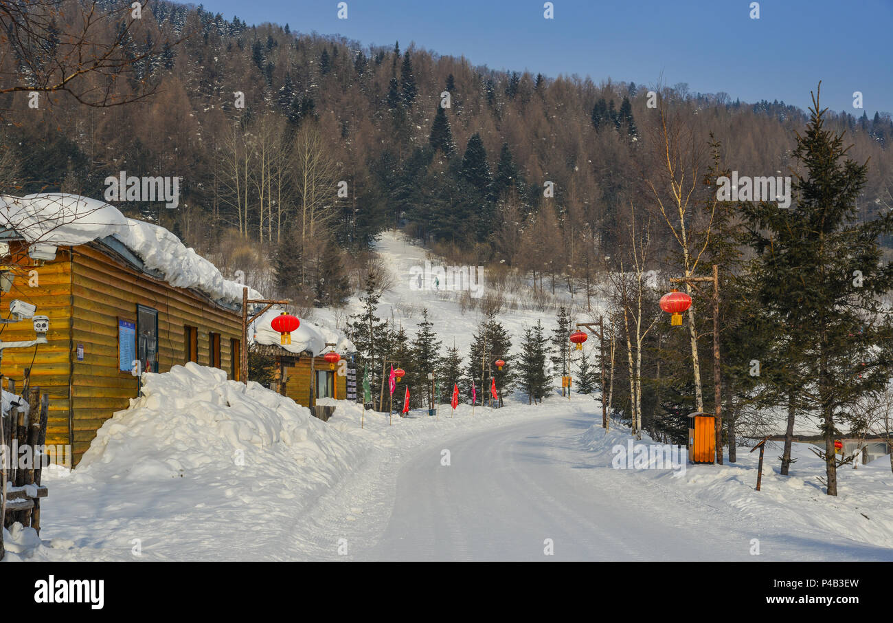 Harbin, China - Feb 24, 2018. Wooden houses covered by snow with red ...