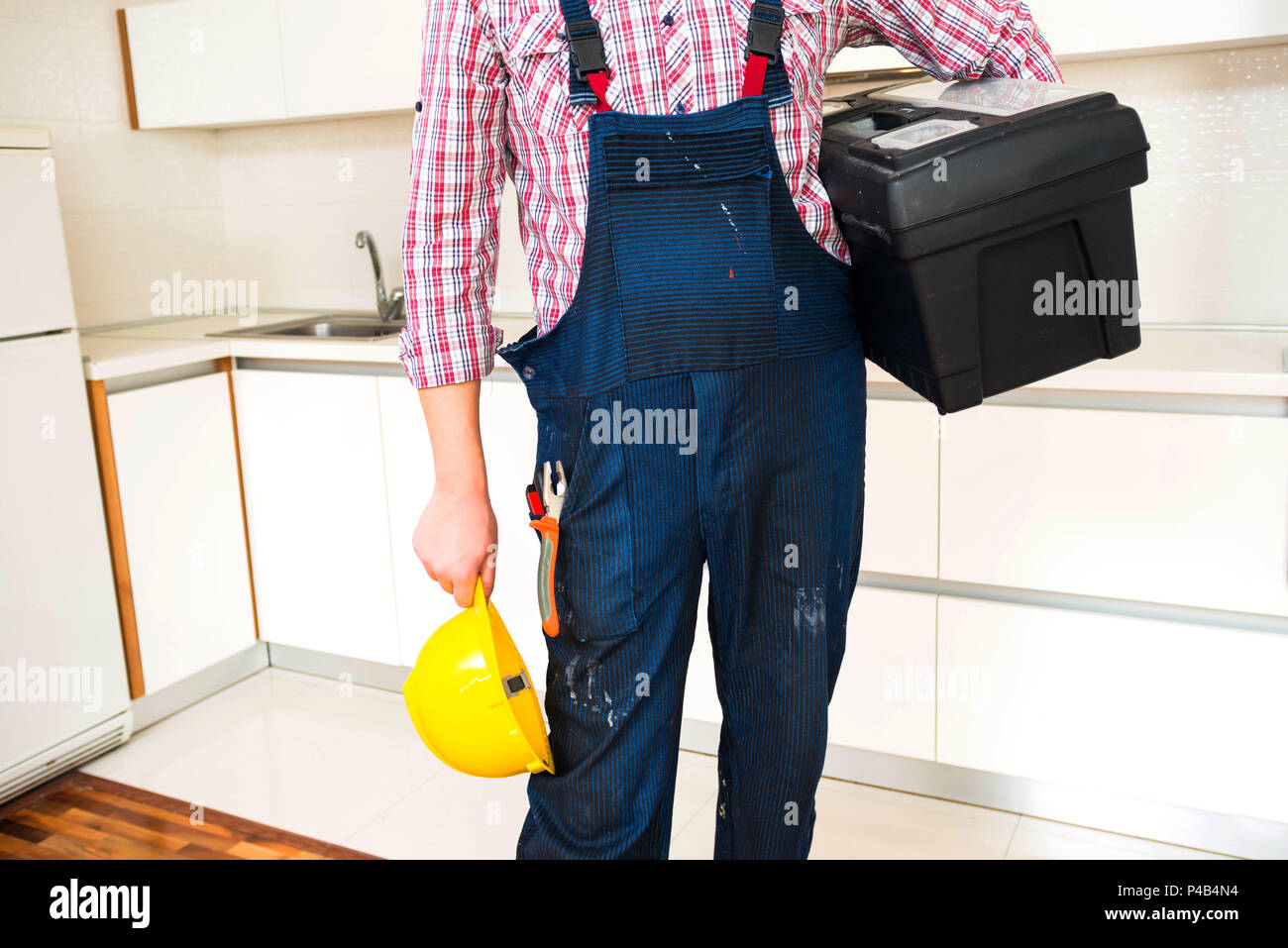 Uniform guy standing with his toolbox in the kitchen Stock Photo - Alamy