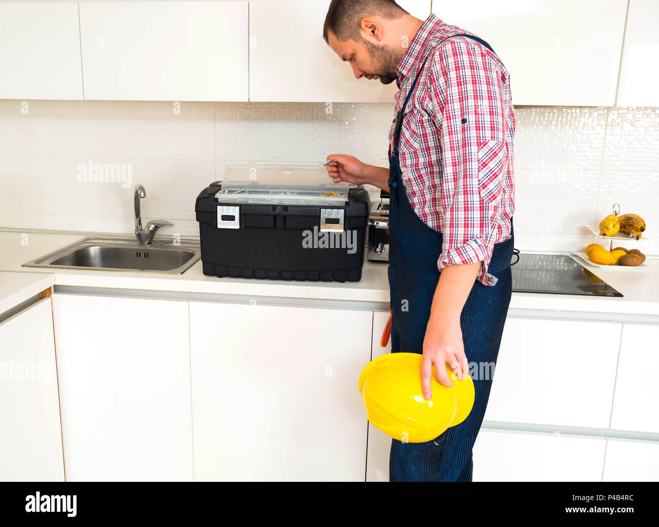 Workman holding his helmet in kitchen Stock Photo - Alamy