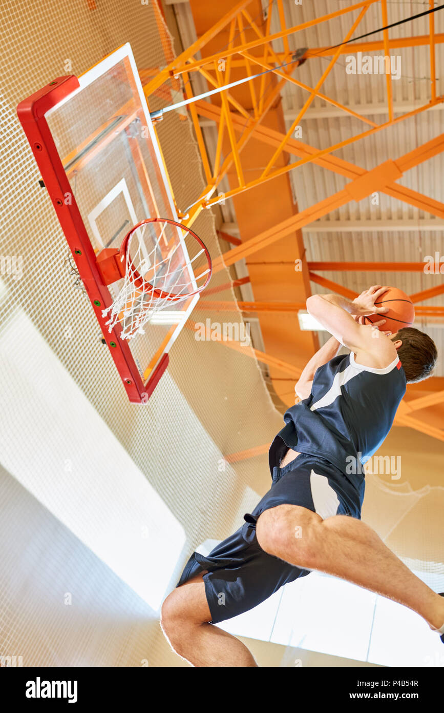 Sportsman jumping and throwing ball into net Stock Photo - Alamy