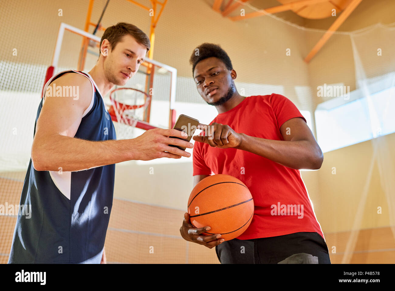 Sportsmen using smartphone on basketball court Stock Photo - Alamy