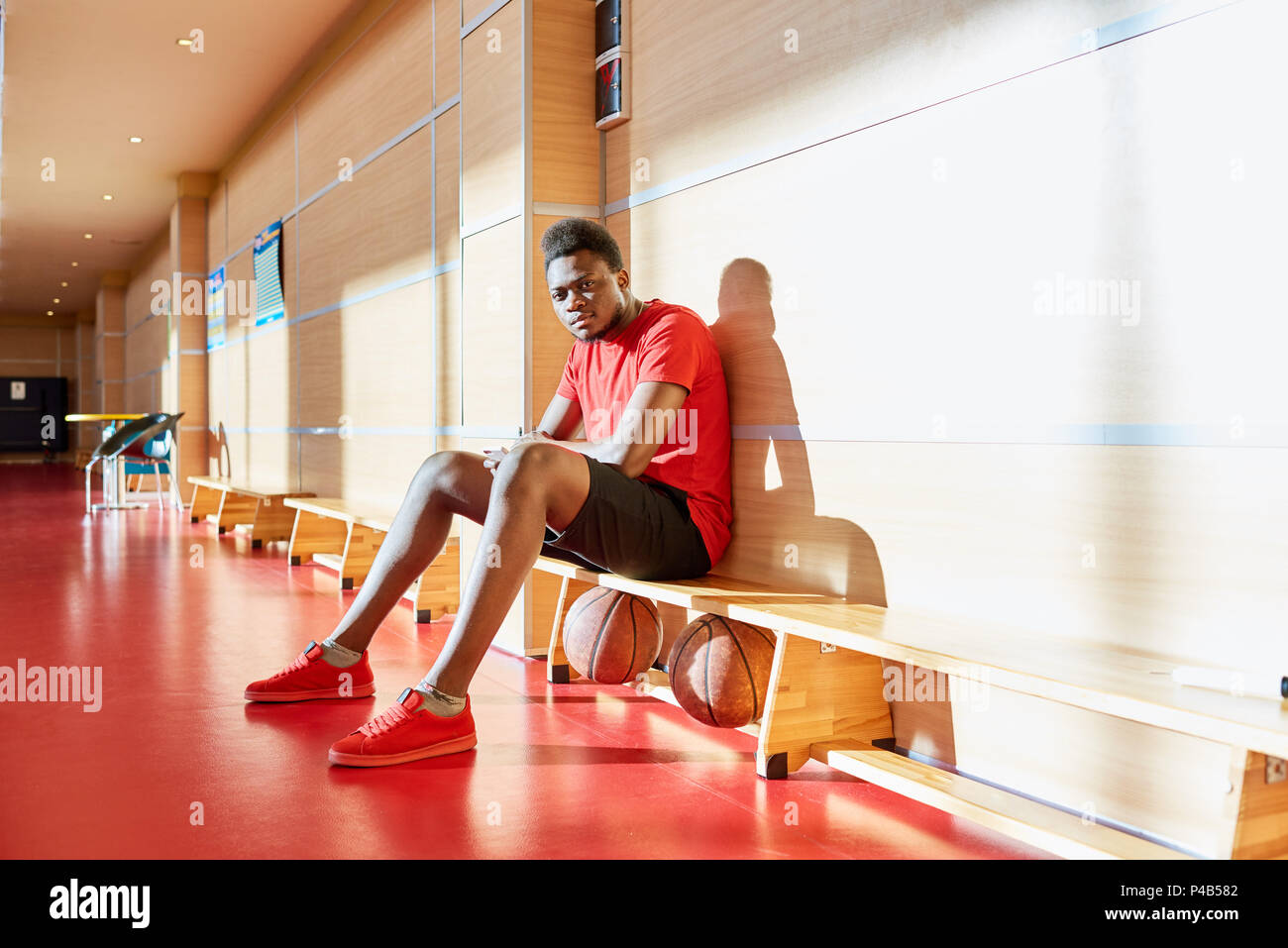 Black basketball player resting on bench Stock Photo - Alamy