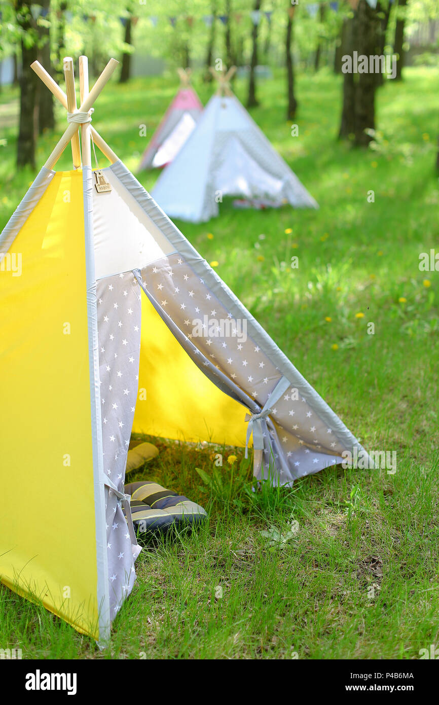 Yellow and blue tents in park Stock Photo - Alamy