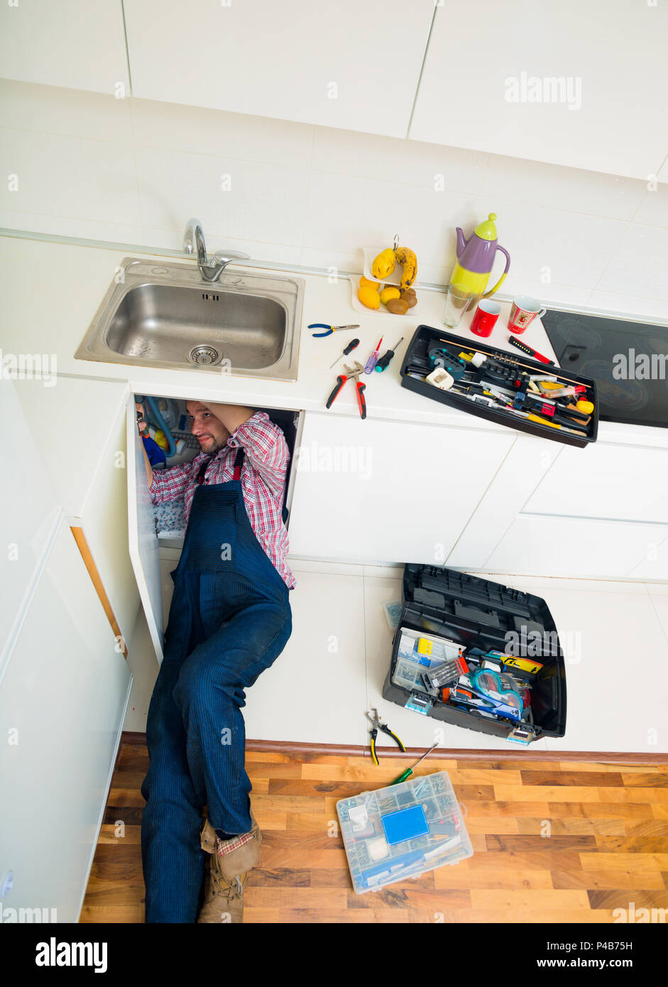 Worker repairs the leakage problem in the kitchen sink Stock Photo - Alamy