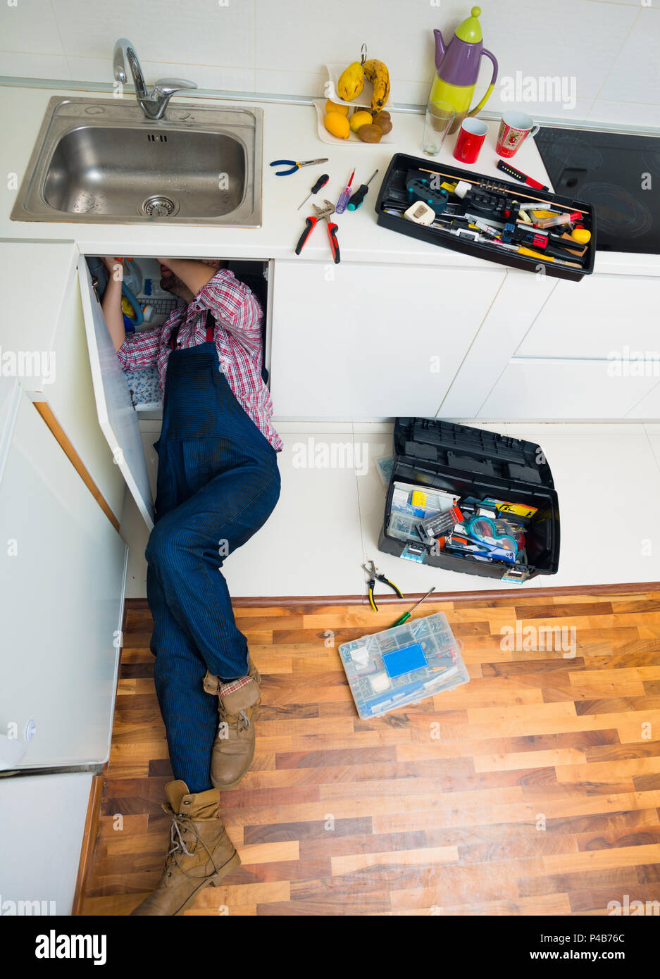 Worker repairs the leakage problem in the kitchen sink Stock Photo - Alamy