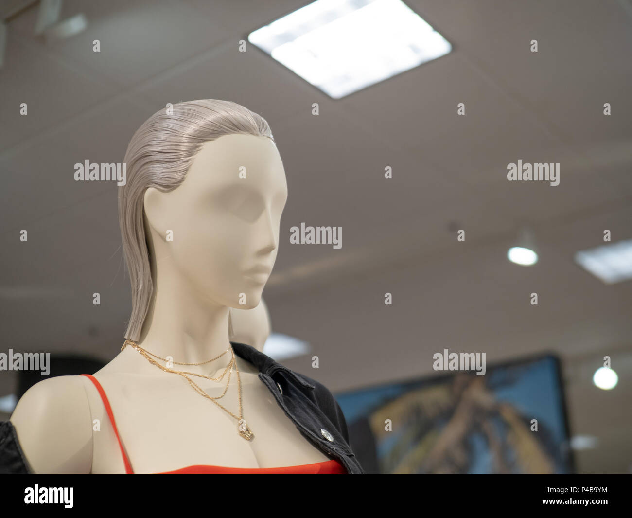 A female mannequins wearing leather jacket and necklace in department ...
