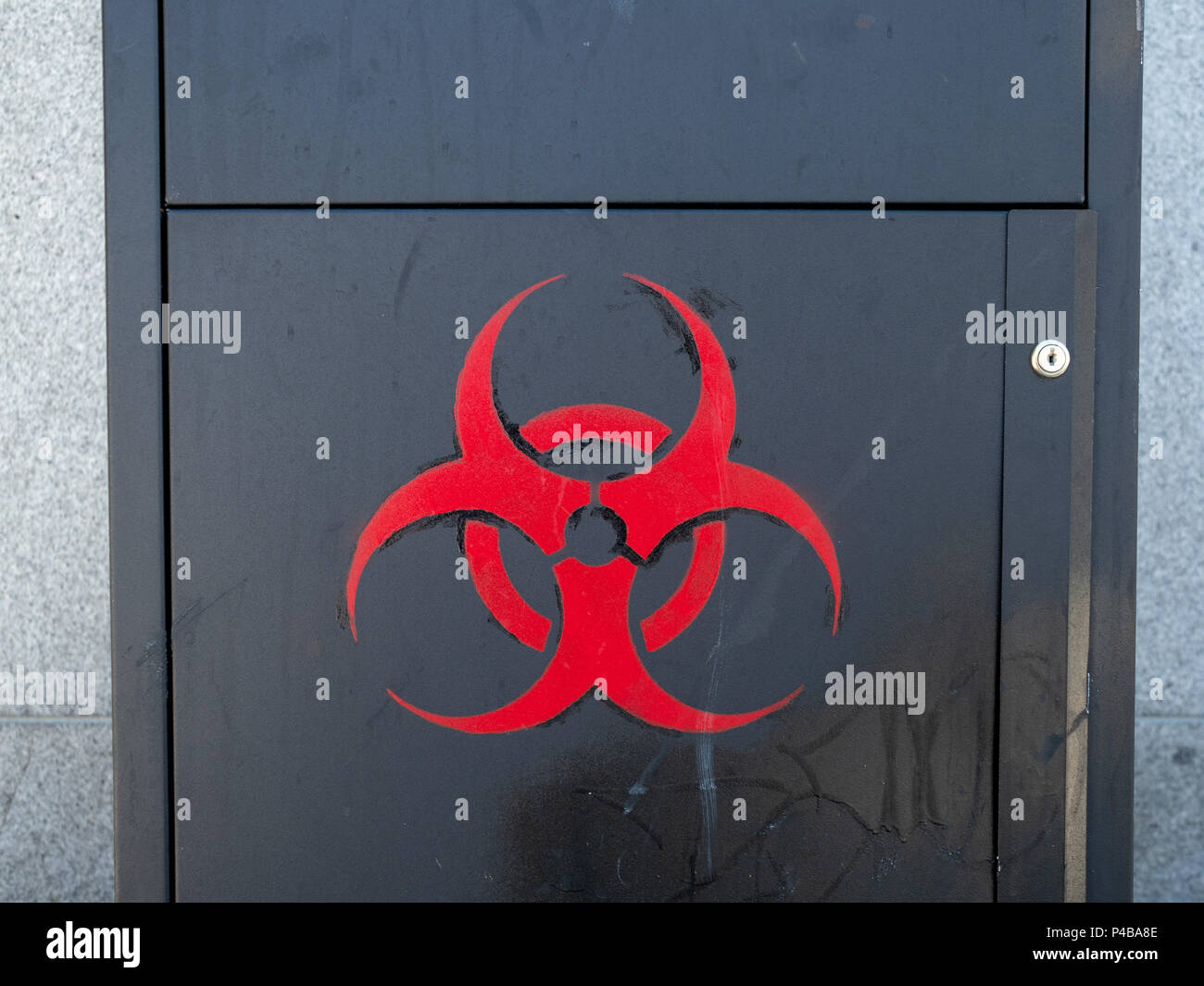 A biohazard spray painted logo and warning on an outdoor steel ...