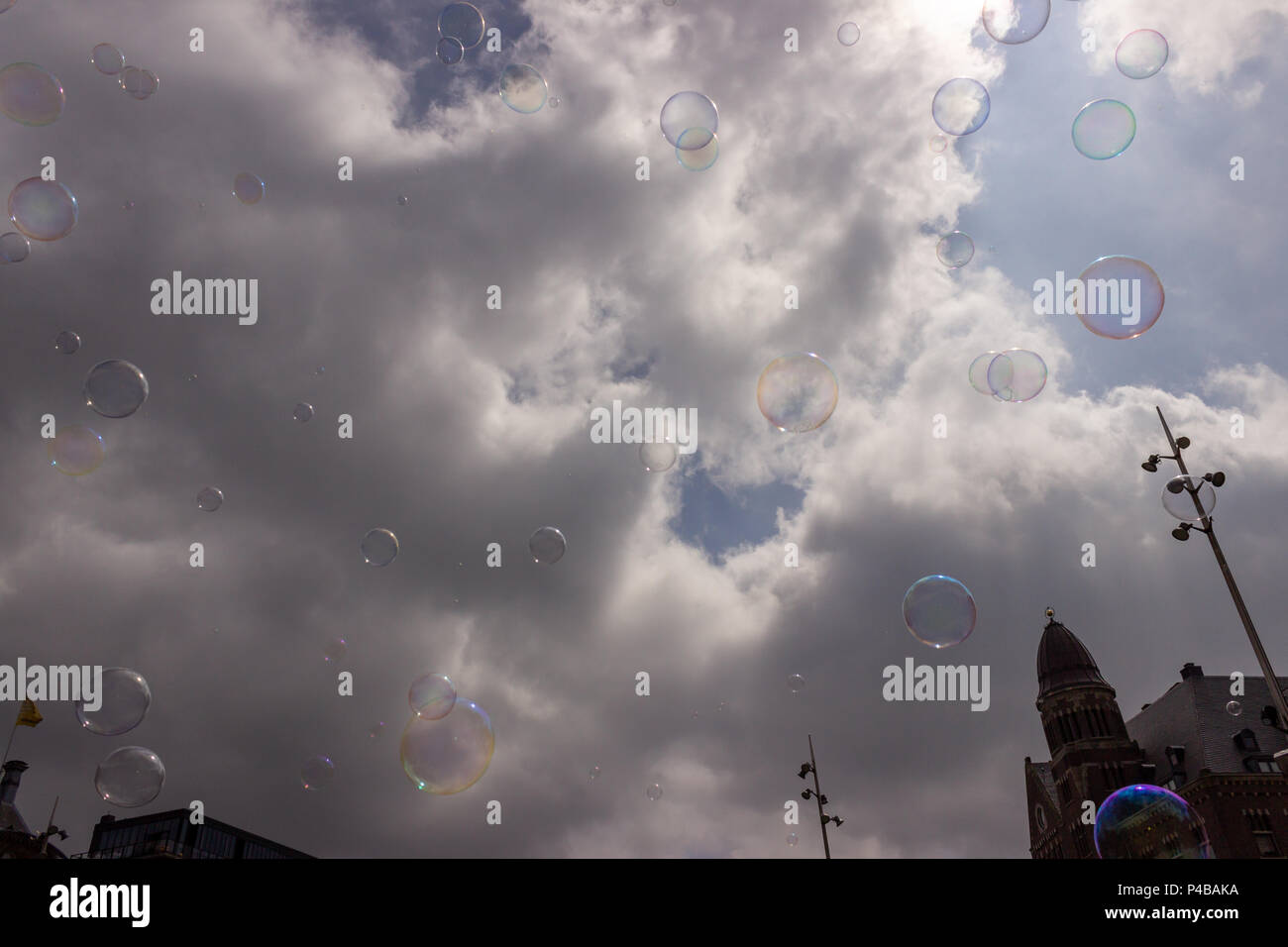 Bubbles float through the sky above Dam Square, Amsterdam, Netherlands ...