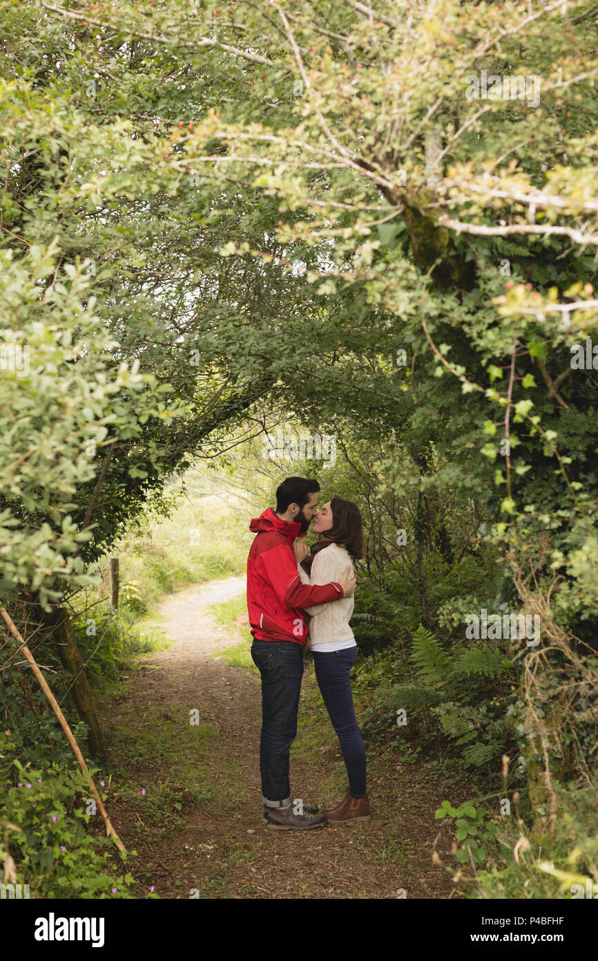 Newly Married Couple Kissing In The Park Near A Tree Stock