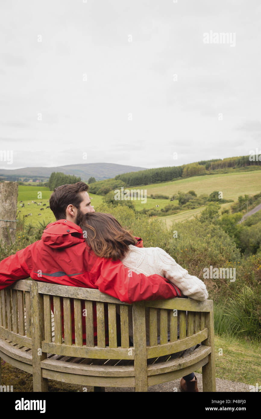 Couple sitting on bench Stock Photo - Alamy