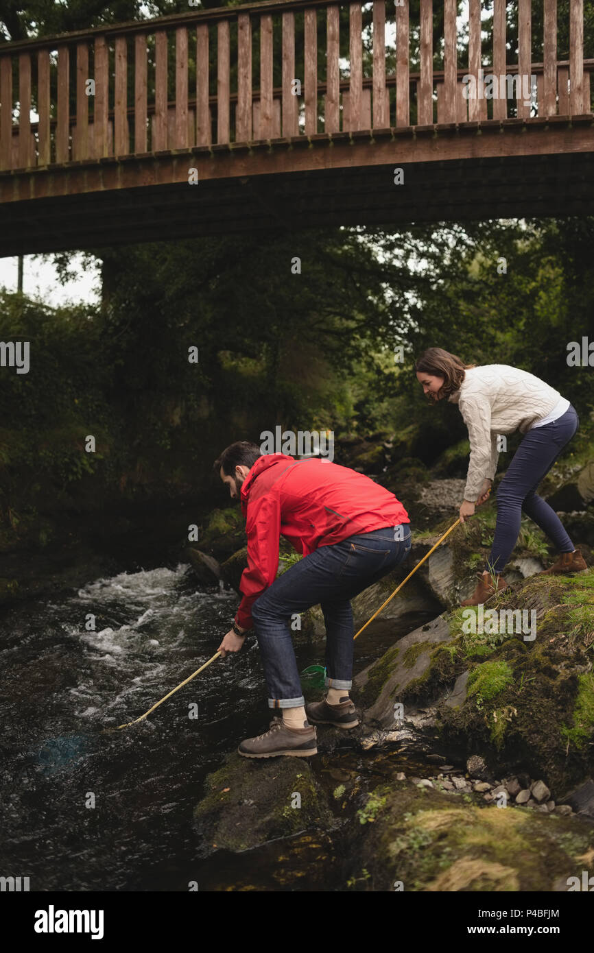 Couple fishing with net in stream Stock Photo - Alamy