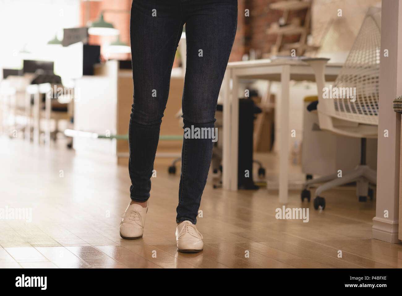 Female executive walking on wooden floor in the creative office Stock ...