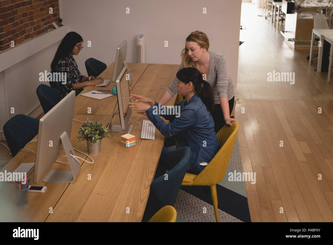 Female executives discussing over computer Stock Photo - Alamy