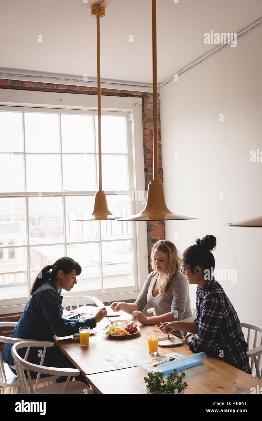 Female executives having breakfast in the creative office Stock Photo ...