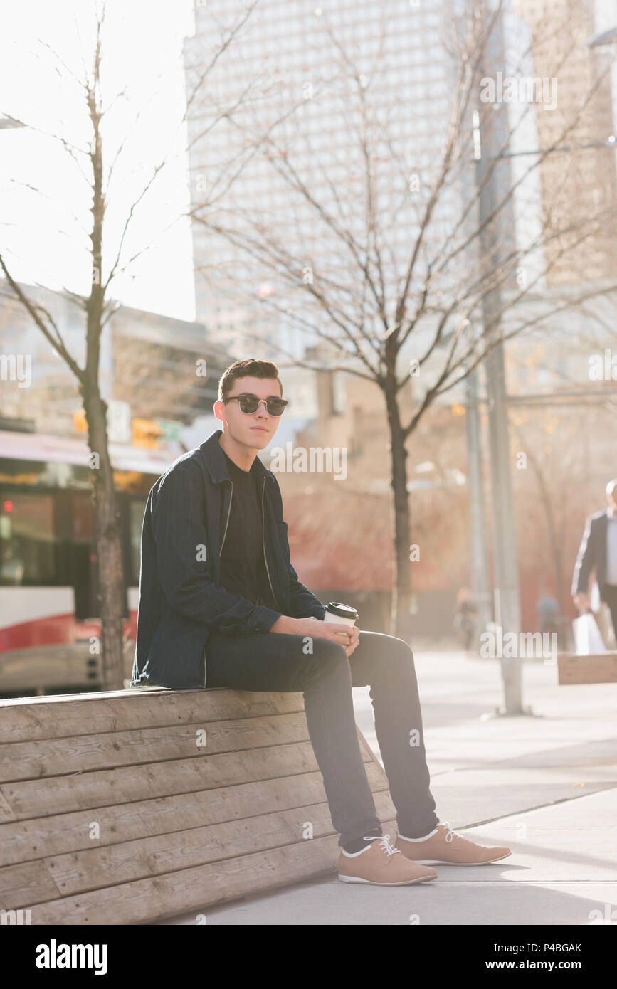 Man sitting near the street side Stock Photo - Alamy