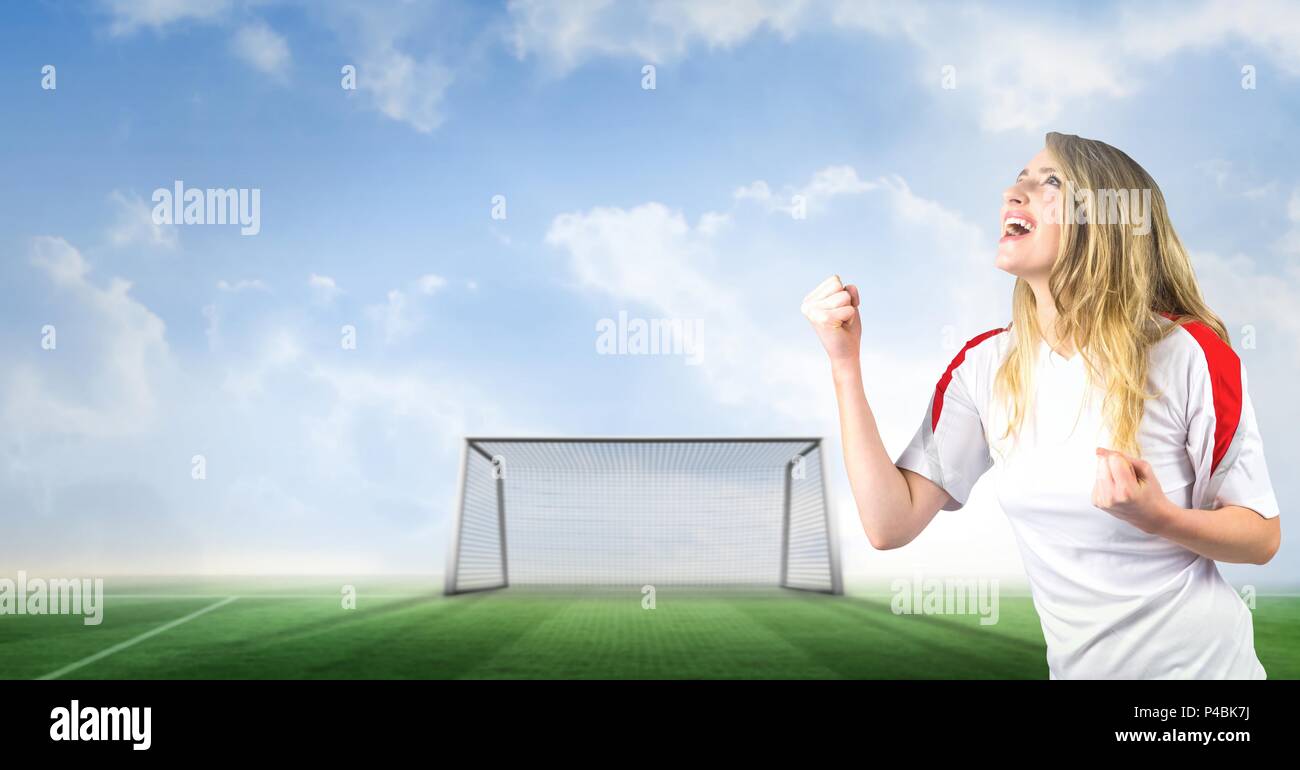 Soccer fan celebrating with fist and goal on pitch Stock Photo - Alamy