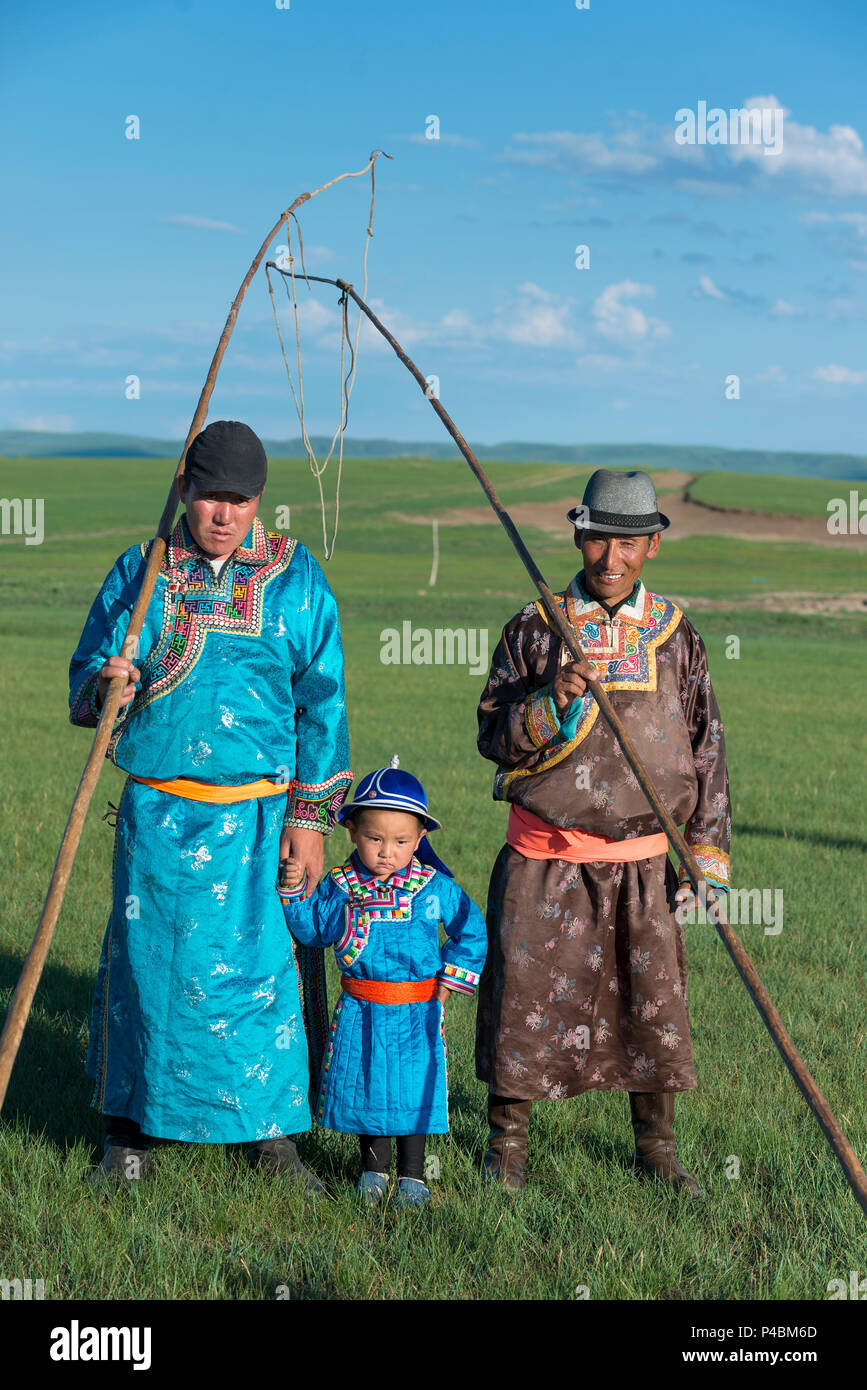 Wearing traditional Mongolian dress, a young boy pridefully stands with ...