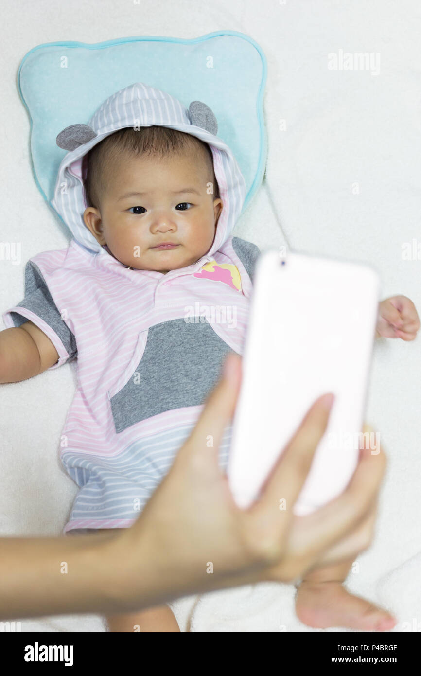 Cute new born baby looking mobile phone in hand Stock Photo - Alamy