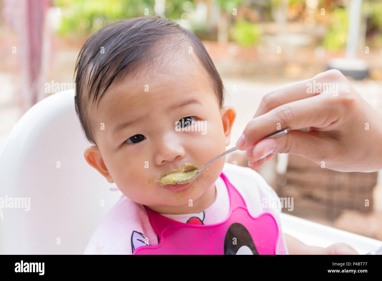 Asian cute baby eating food, Mother feeding first solid food for young ...