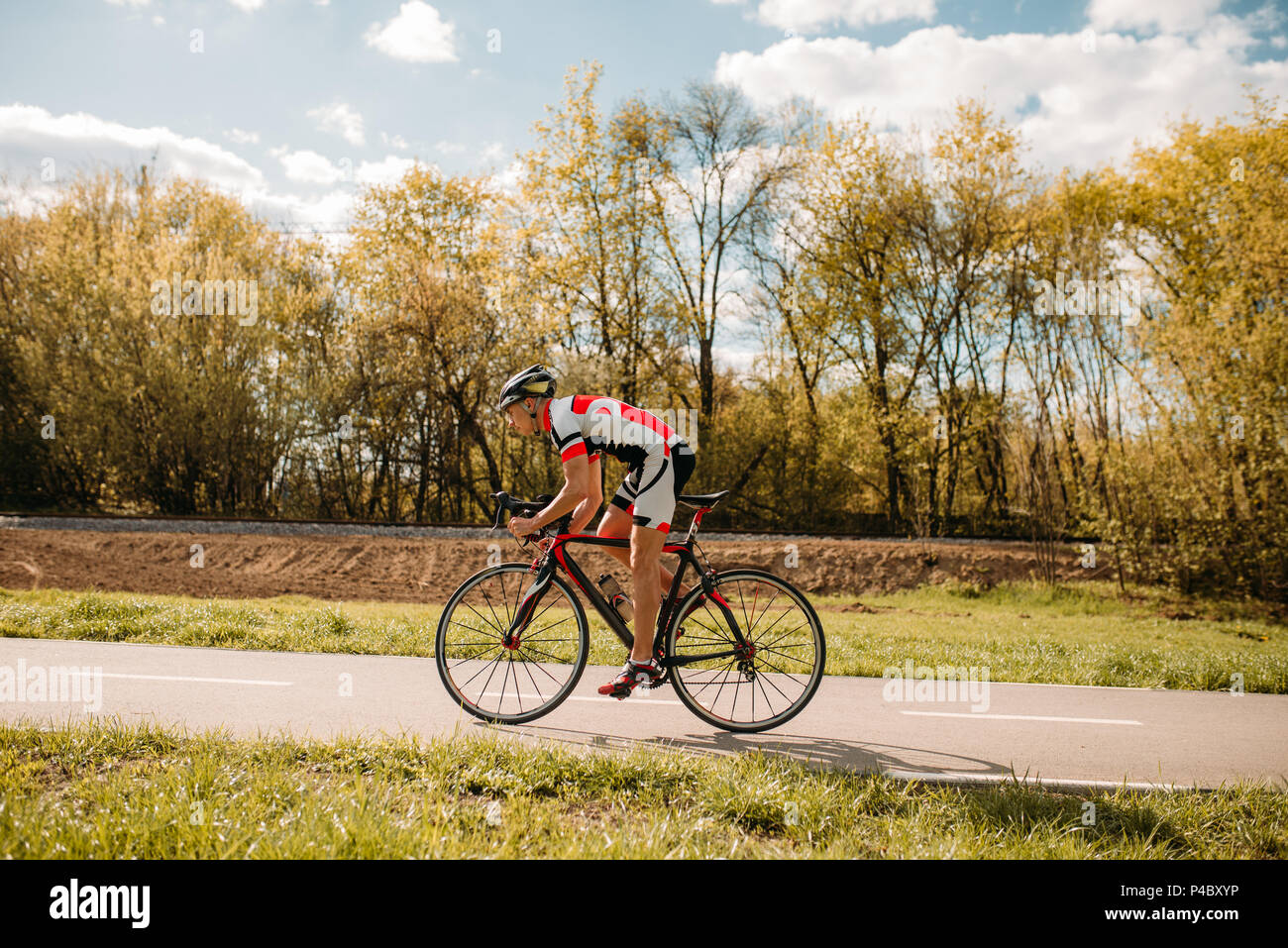 Cyclist rides on bicycle, side view Stock Photo - Alamy
