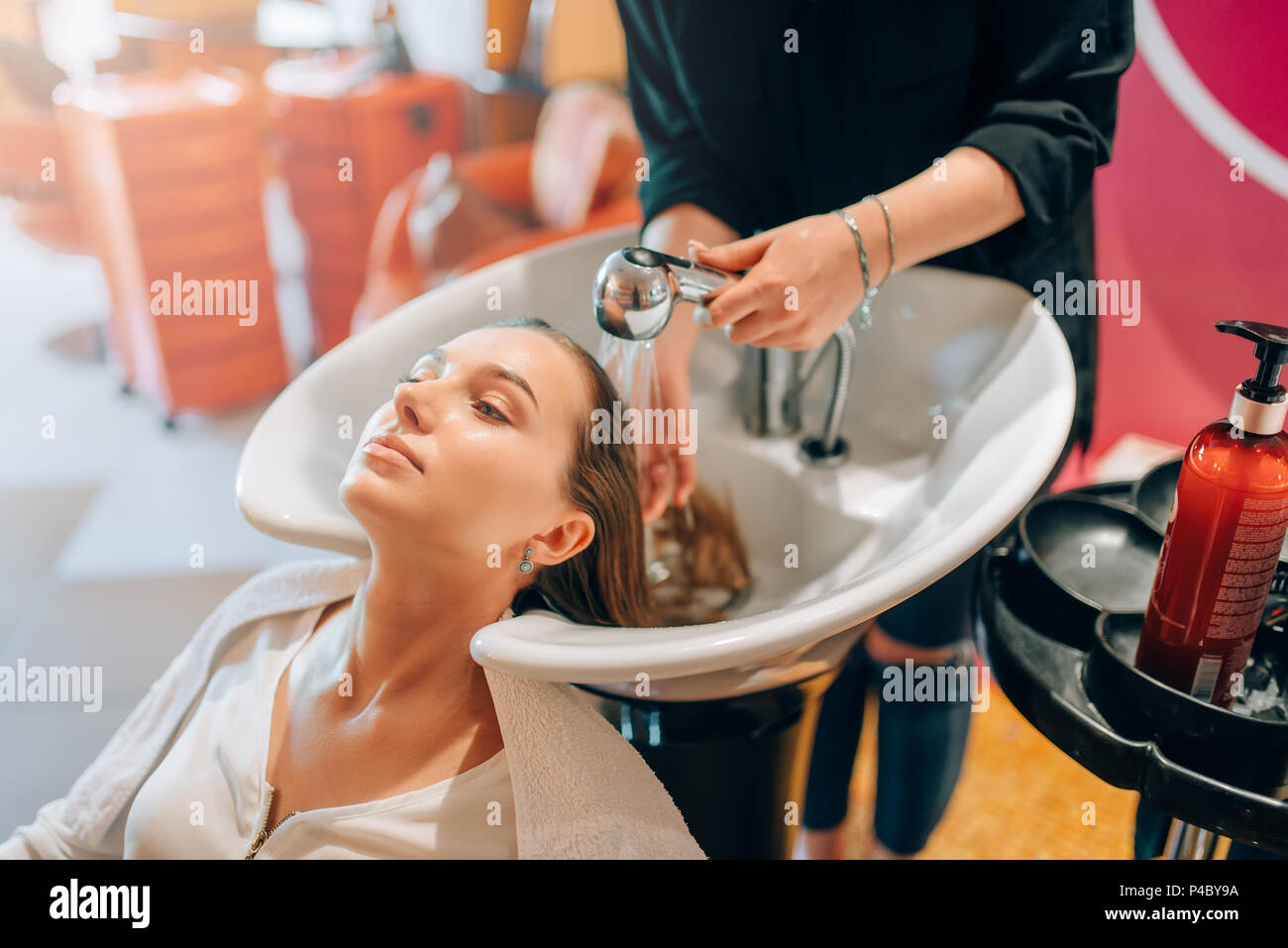 Hairdresser washes customer hair in basin Stock Photo - Alamy