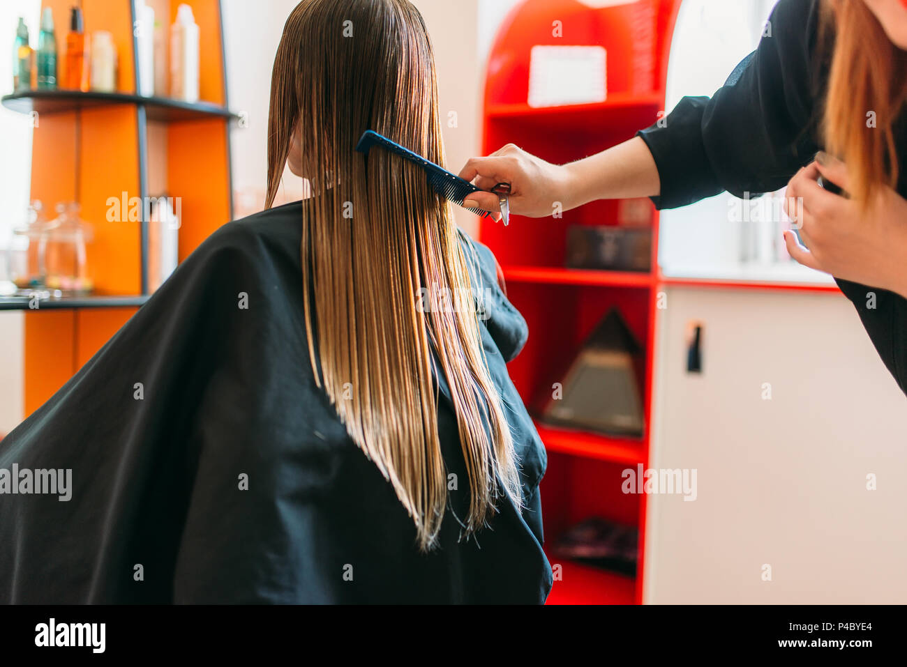 Hairdresser runs the comb, female client Stock Photo - Alamy