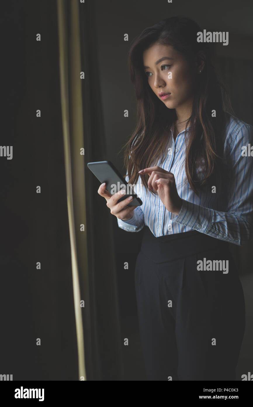 Young businesswoman using mobile phone at desk in office Stock Photo ...