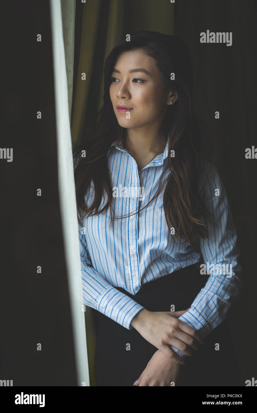 Businesswoman looking through window Stock Photo - Alamy